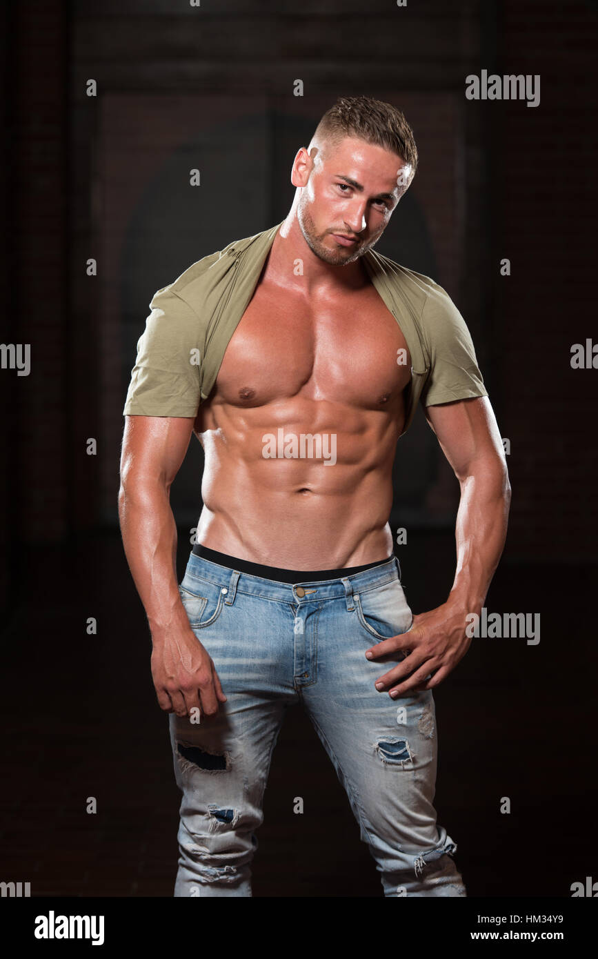 Portrait Of A Young Physically Fit Man In Jeans And T-shirt Showing His ...
