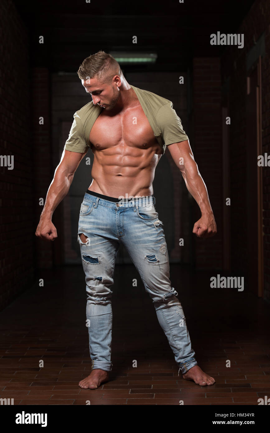 Portrait Of A Young Physically Fit Man In Jeans And T-shirt Showing His ...