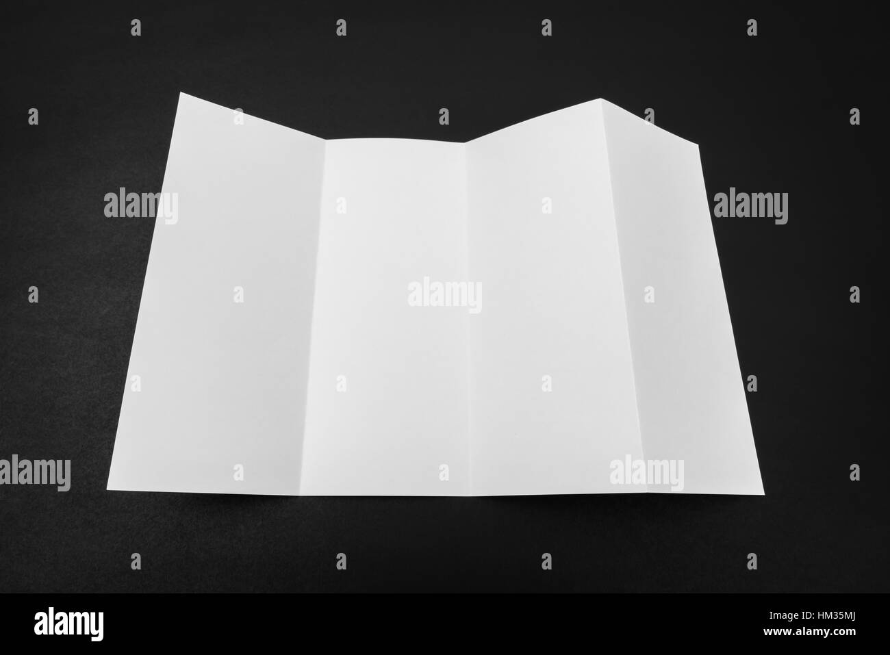 Four - fold white template paper on black background Stock Photo - Alamy