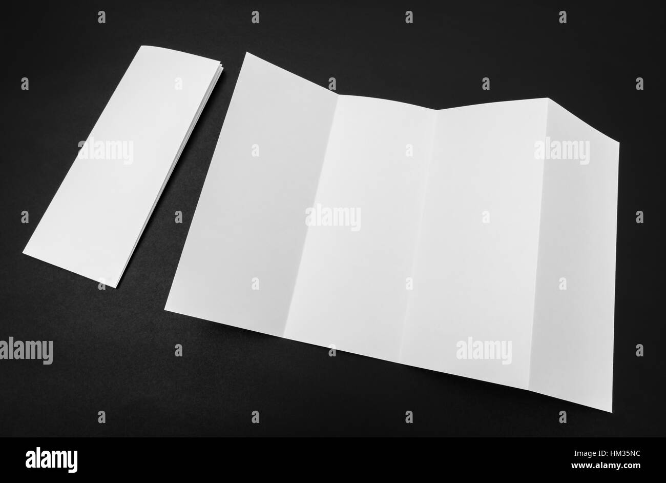 Four - fold white template paper on black background Stock Photo - Alamy