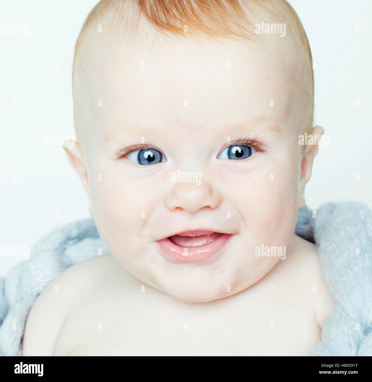 little cute red head baby in scarf all over him close up isolate Stock ...