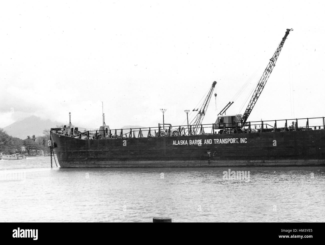 A crane and a forklift are visible on the deck of a large vessel ...