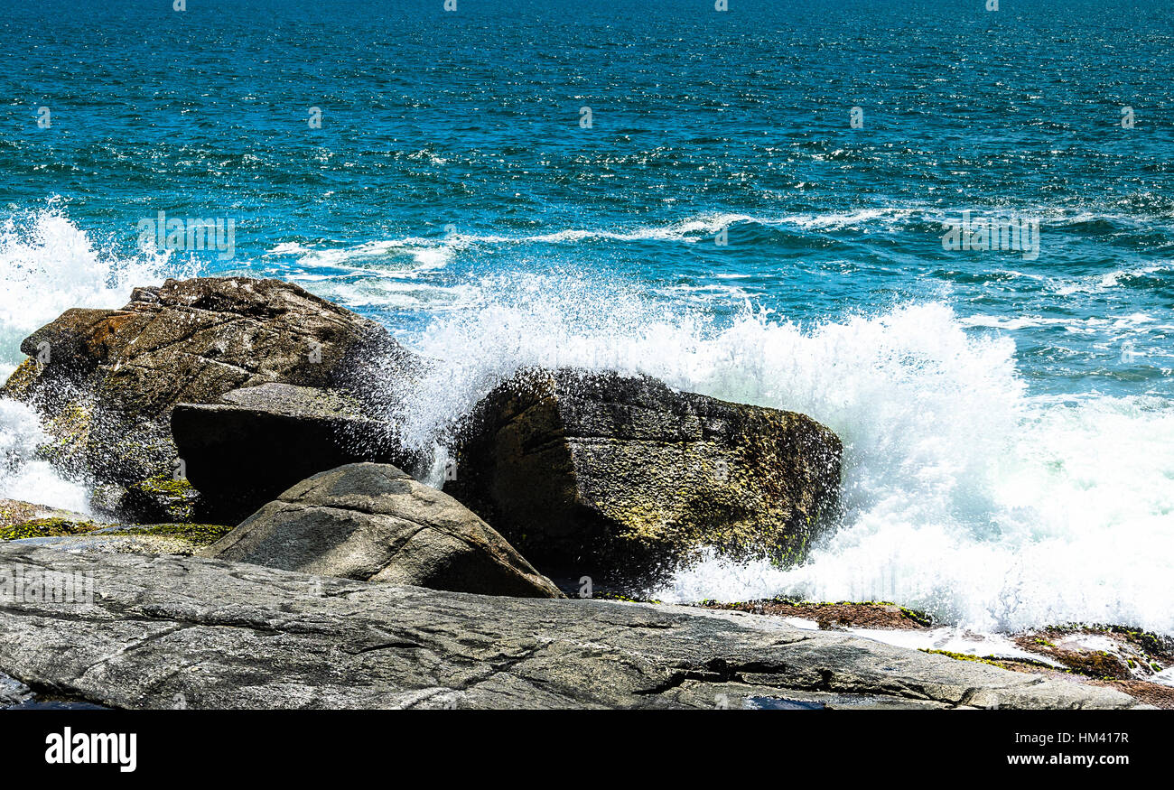 Sea water splashing on the rocks. Waves from a blue ocean hitting the ...
