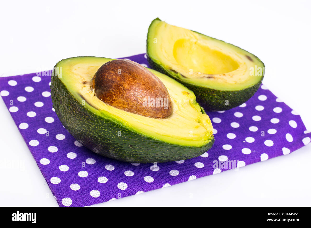 Sliced avocado with stone on blue background Stock Photo - Alamy