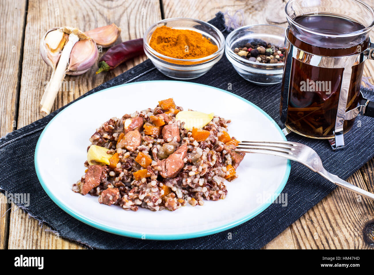 Pilaf with red rice with chunks of beef, carrots and garlic Stock Photo ...