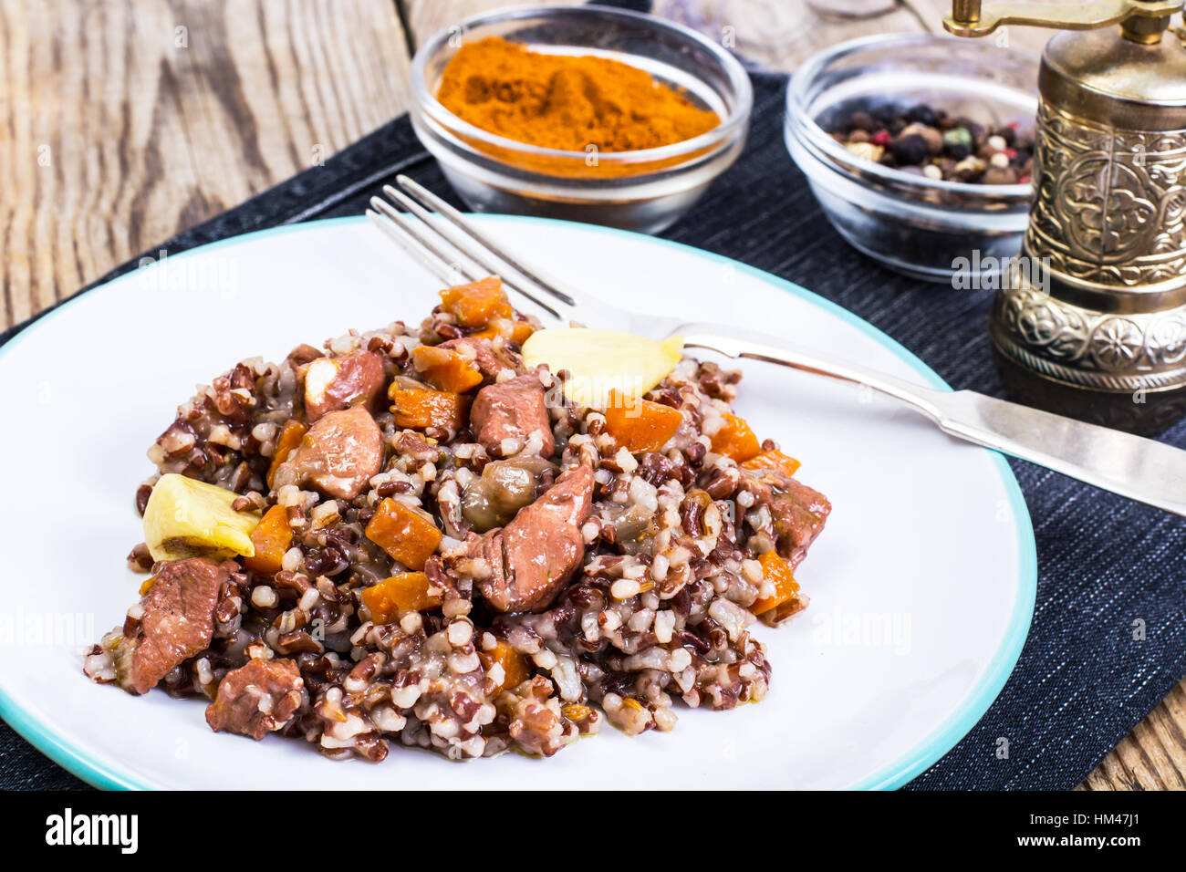 Pilaf with red rice with chunks of beef, carrots and garlic Stock Photo ...