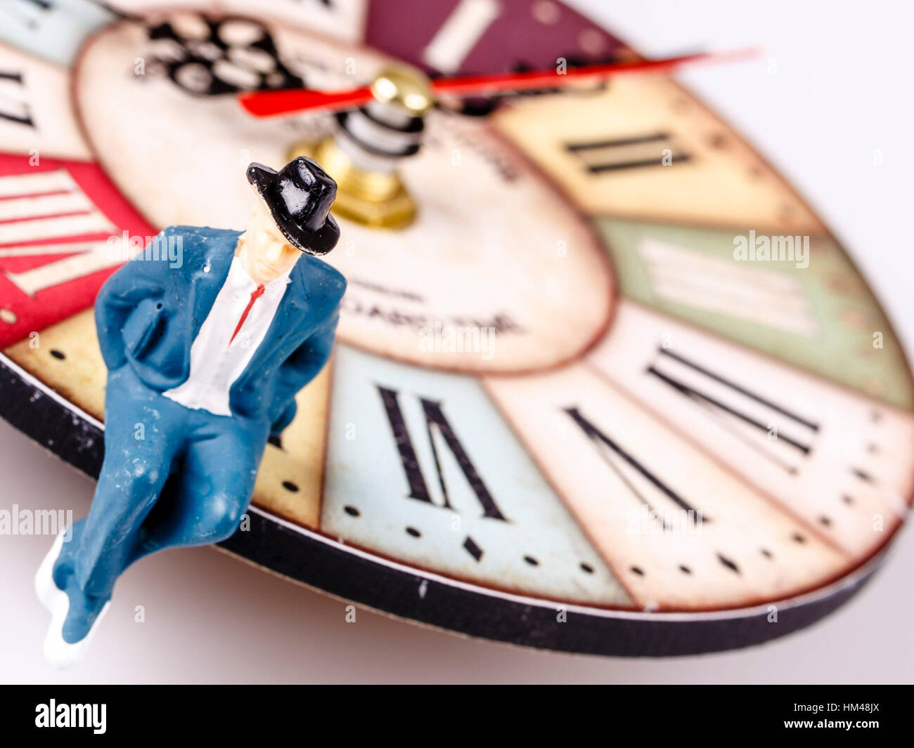 model of man sitting on beautiful old clock on white, retro style Stock ...