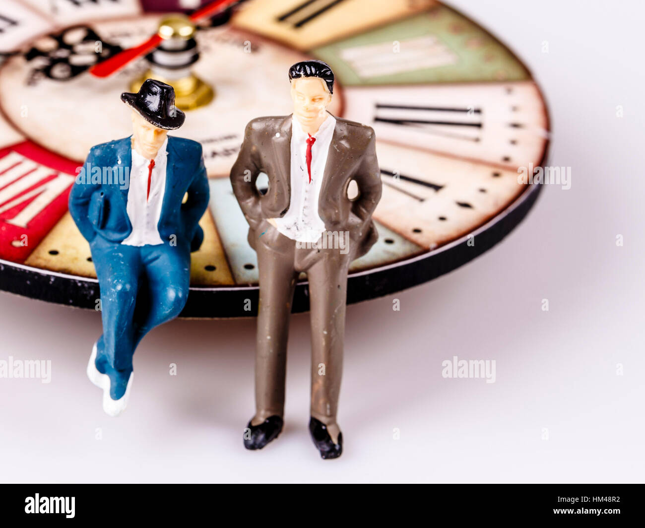 model of man sitting on beautiful old clock on white Stock Photo - Alamy