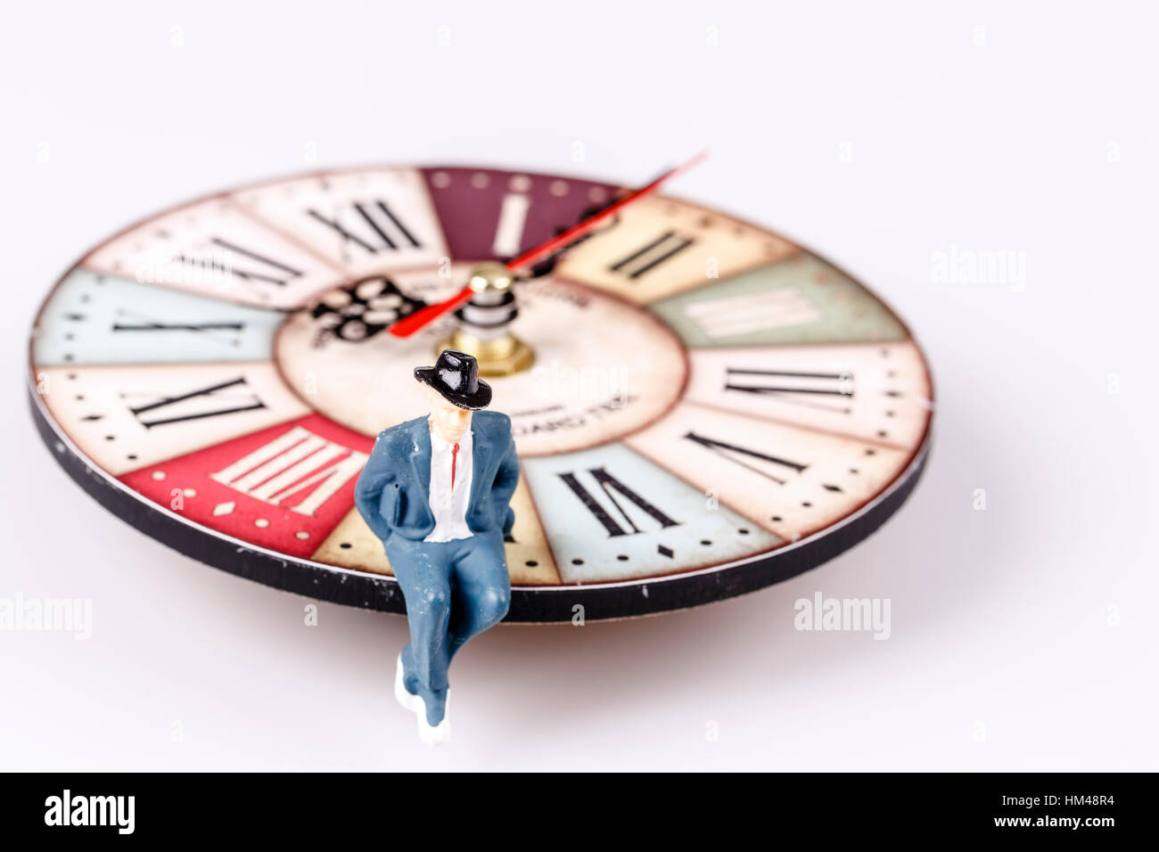model of man sitting on beautiful old clock on white Stock Photo - Alamy