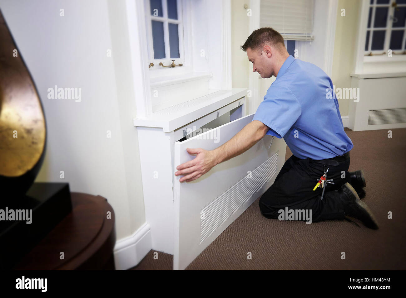 Workman fixing a radiator cover to the front of a radiator Stock Photo ...
