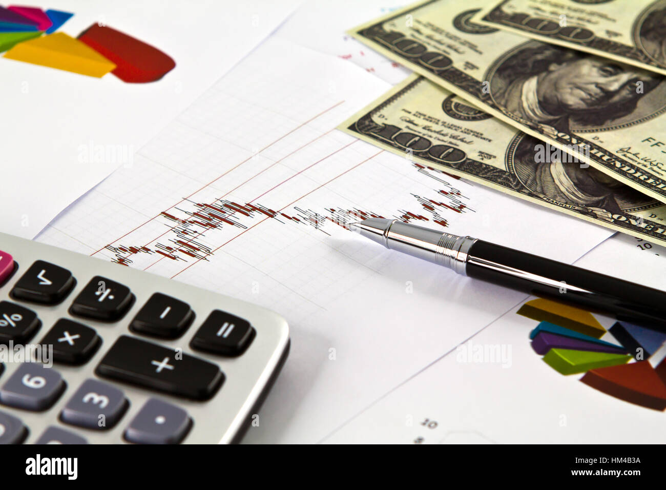 Pen ,calculator and dollars on financial Graphs Stock Photo - Alamy