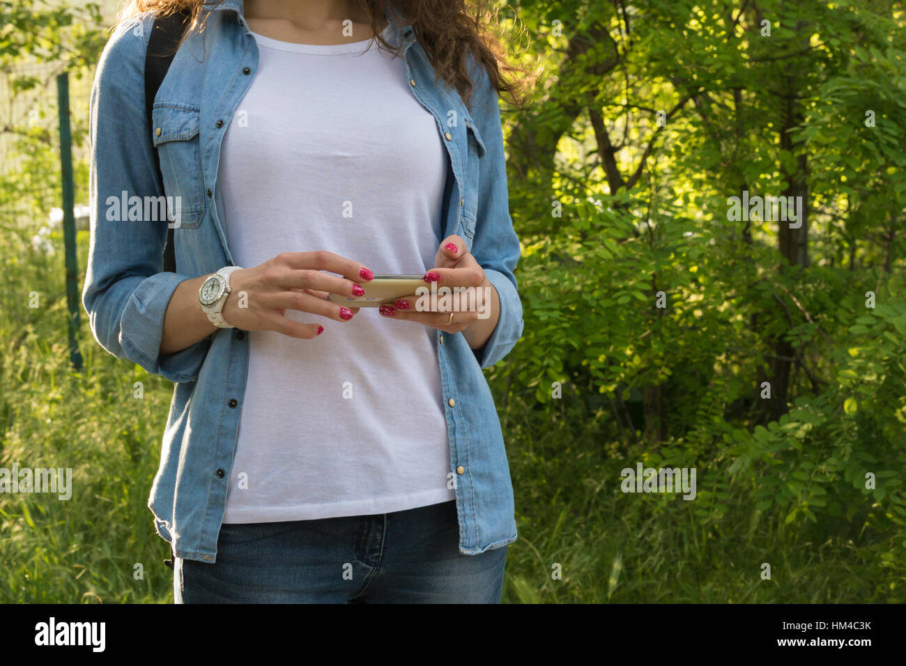 Young woman using a mobile phone during a hike with a backpack on ...
