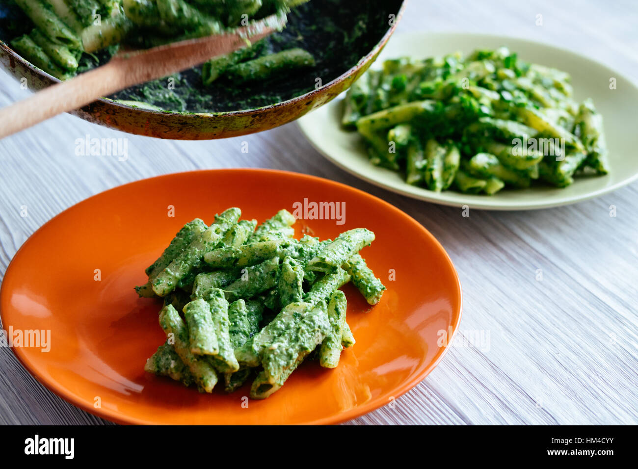 Two plates with spinach pasta. One plate portion poured food Stock ...