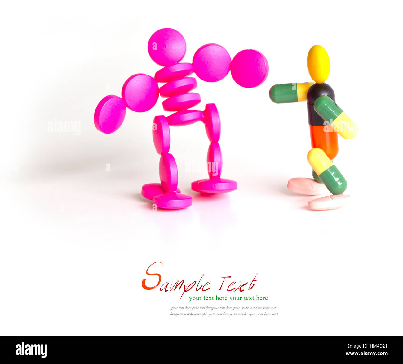 Two colorful robot (made of capsules and tablets) stand on white ...