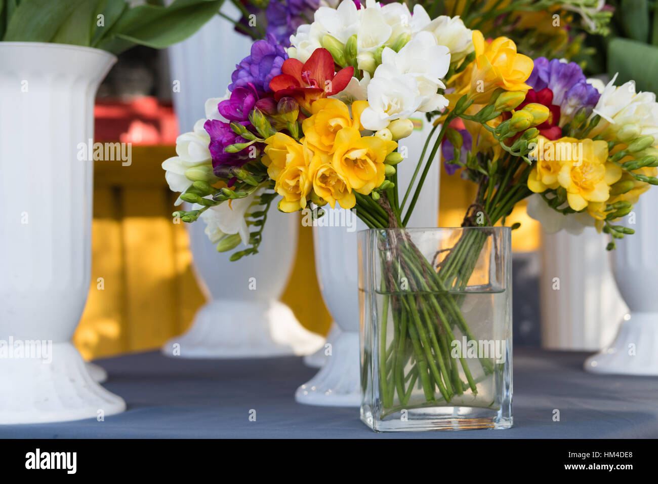 Bright colored flowers in a transparent vase with water Stock Photo - Alamy