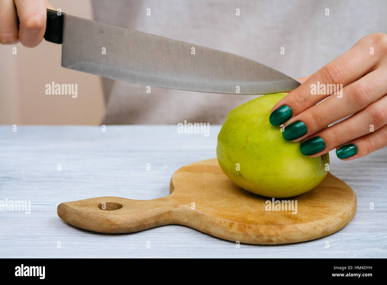 Female hands cut green apple with a knife in the kitchen Stock Photo ...