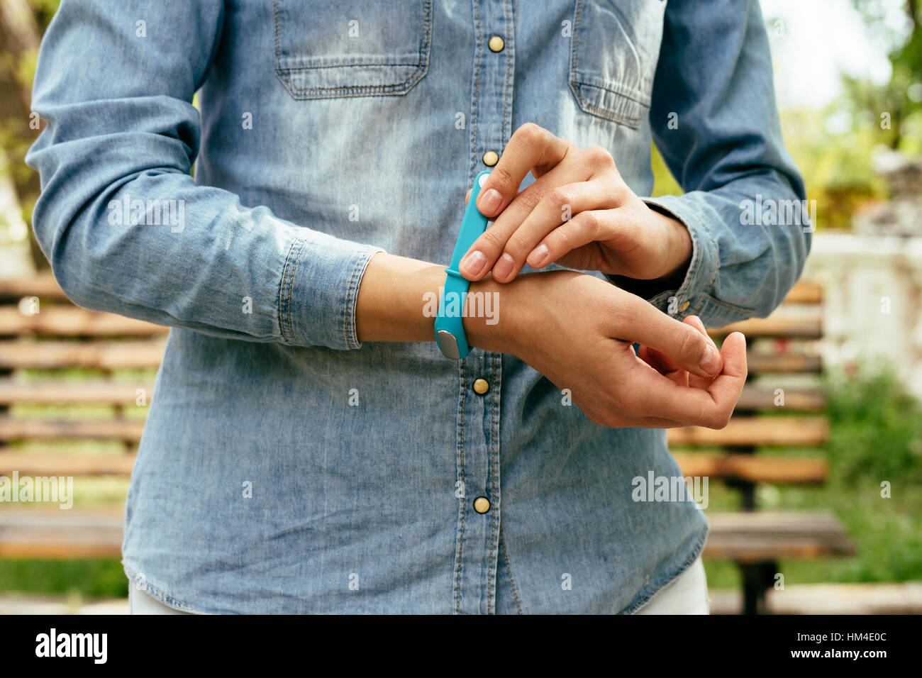Woman in denim shirt wears sports wristband for measuring steps Stock ...