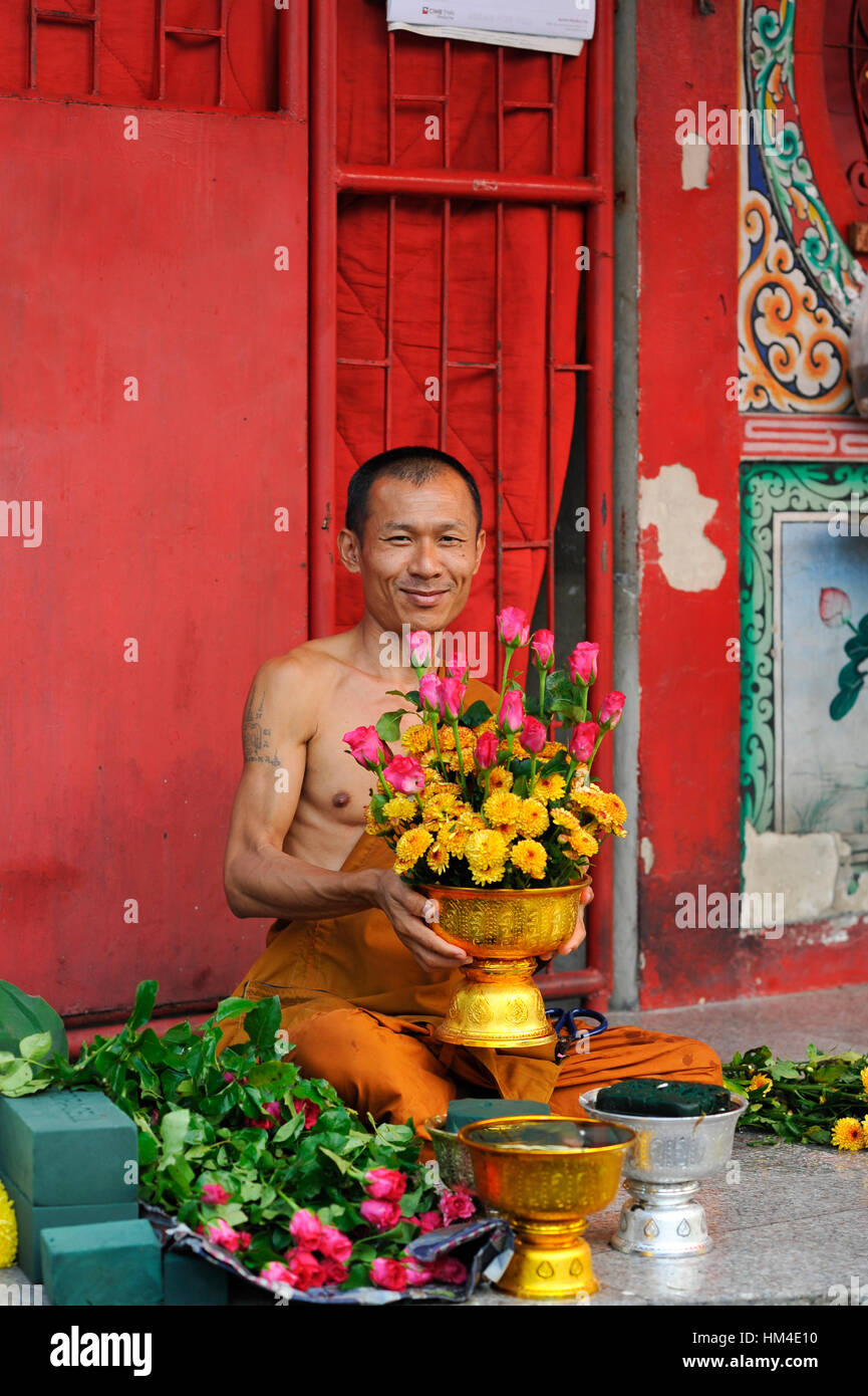 A Thai monk shows off his flower arrangement Stock Photo - Alamy