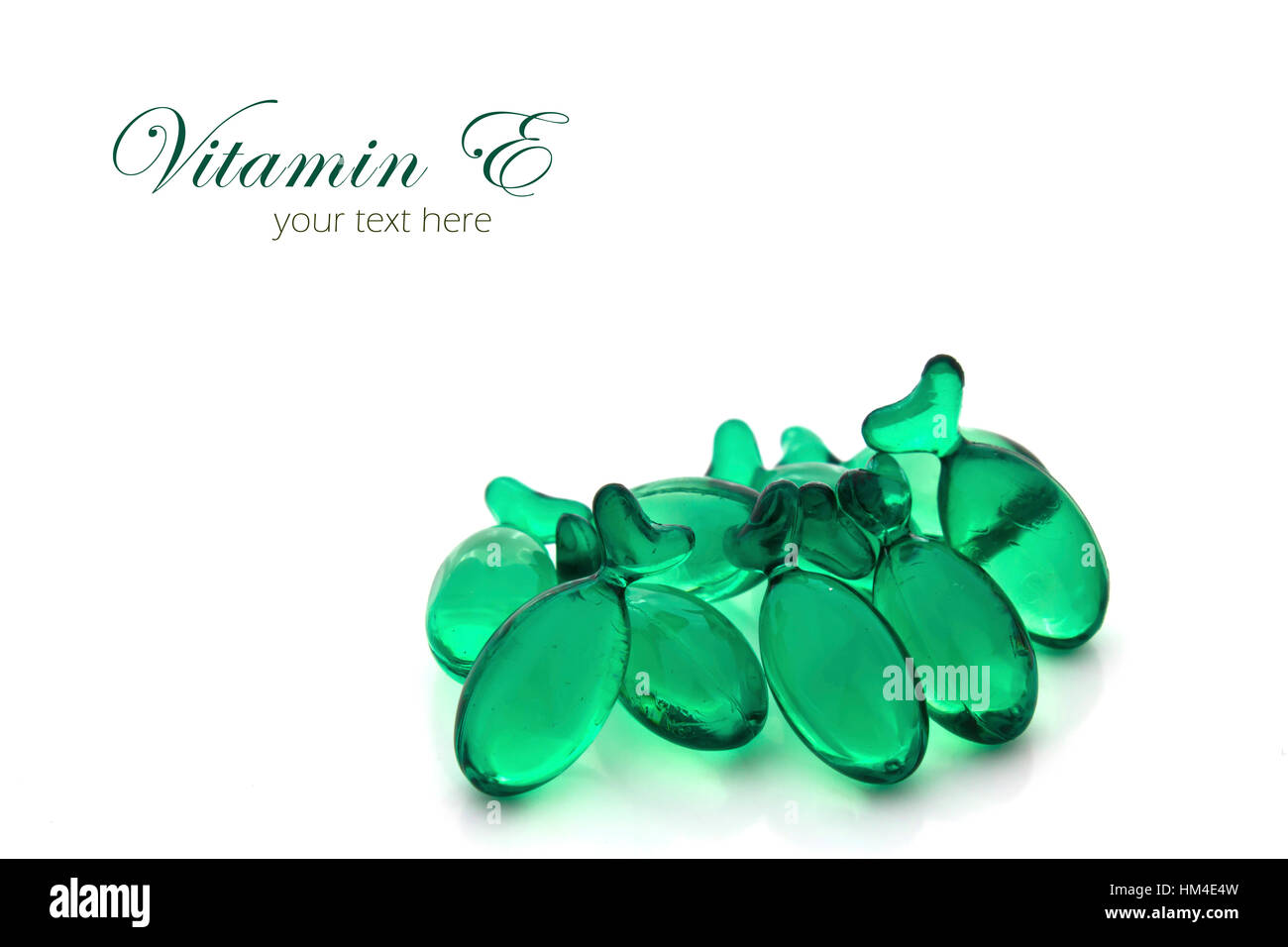 Green transparent pills of vitamin E on white background with copy ...