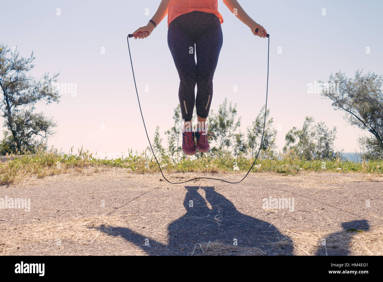 Female feet in sneakers jumping on a skipping rope in summer Stock ...
