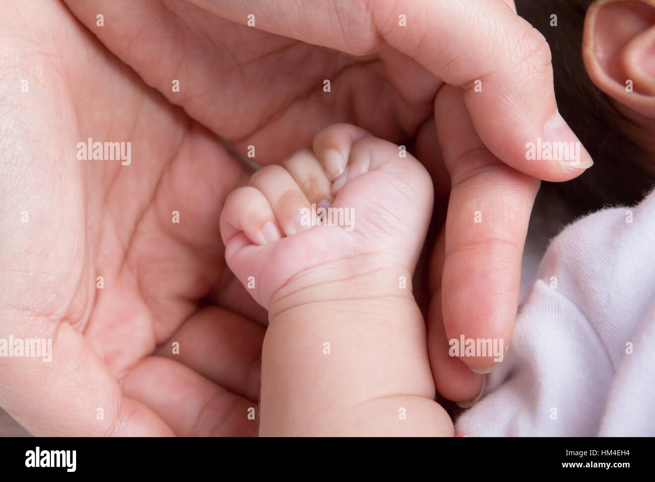 Female hand holding newborn baby hand Stock Photo - Alamy