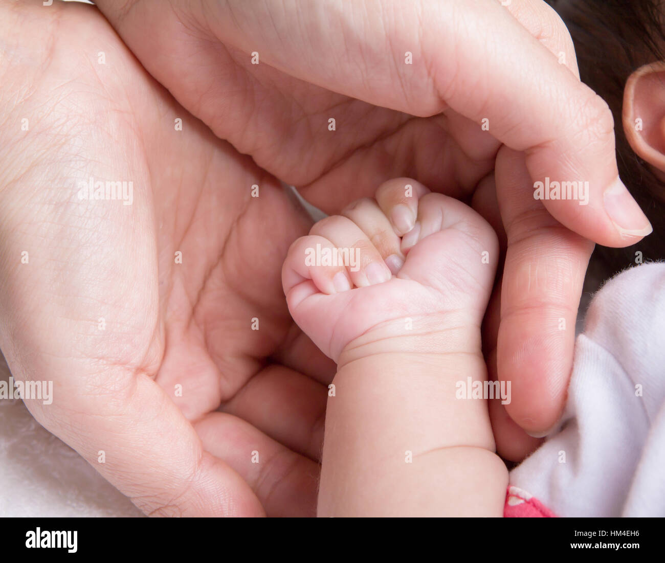 Newborn baby hand over female palm Stock Photo - Alamy