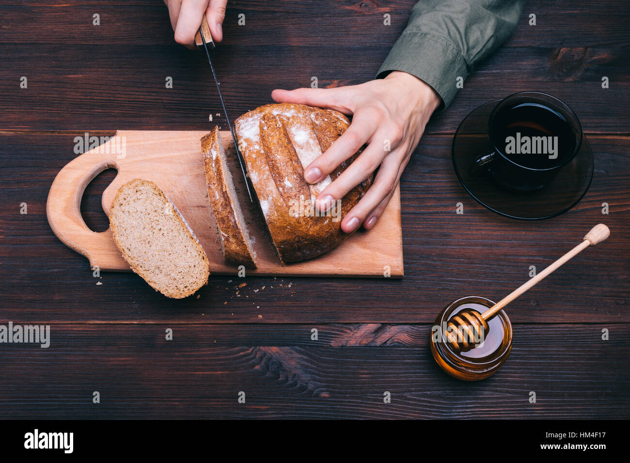 Female hands cut bread on the table top view Stock Photo - Alamy