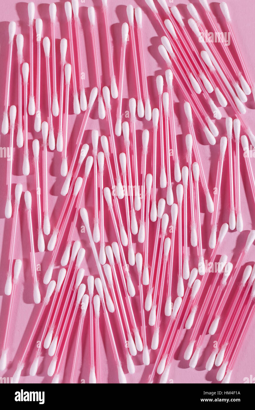 Many cotton swabs on a pink background, top view, vertical framing ...