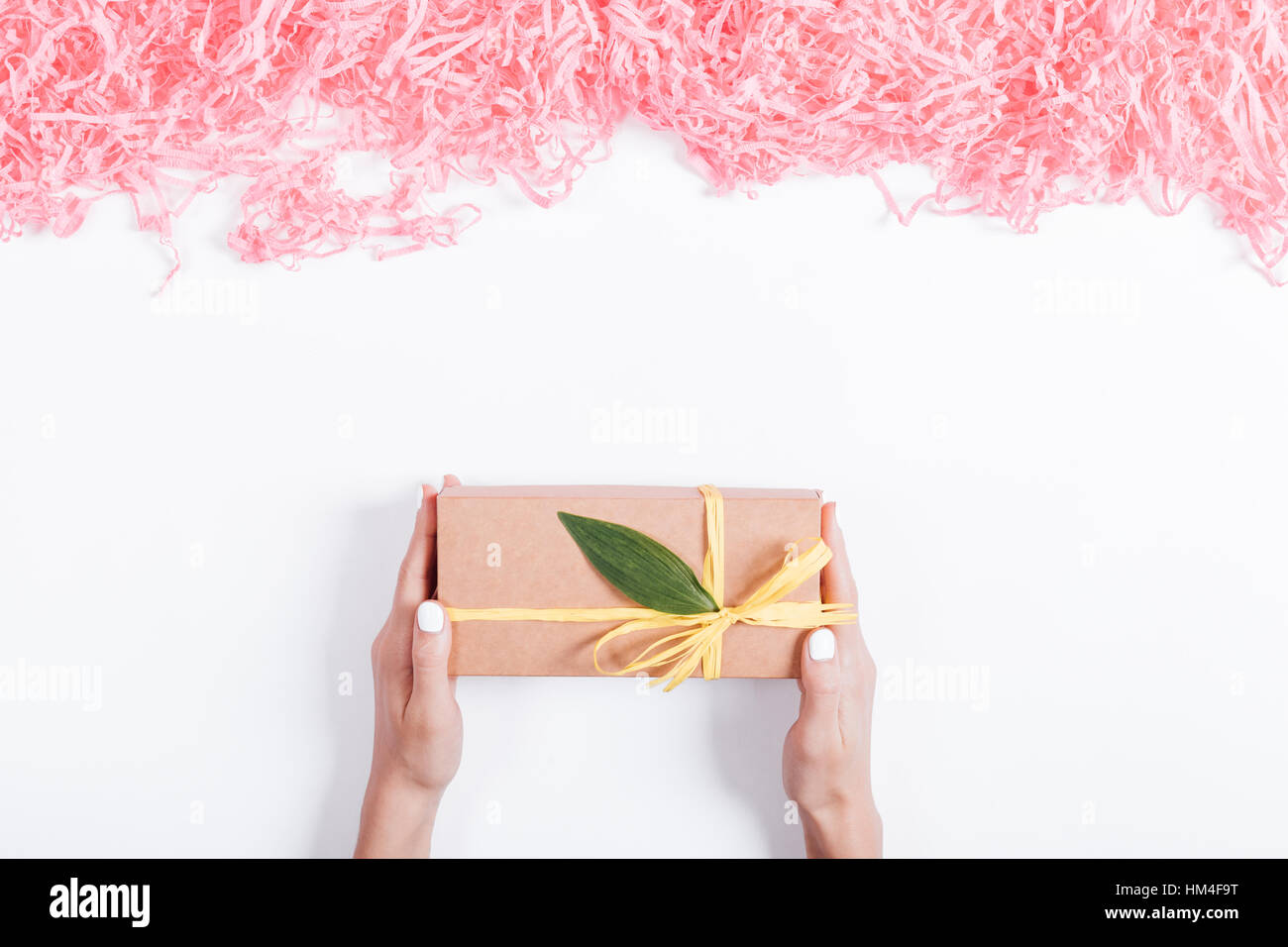 Female hands holding a box with a gift on white background, top view ...