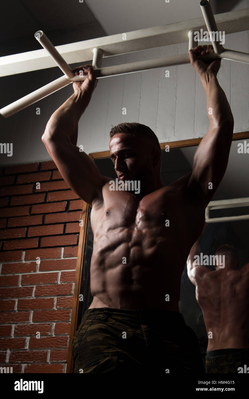 Muscular Man Performing Hanging Leg Raises Exercise - One Of The Most ...