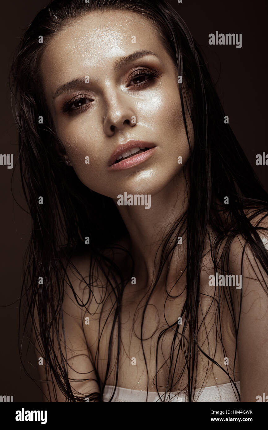 Beautiful girl with a bright make-up, wet hair and skin. Beauty face ...