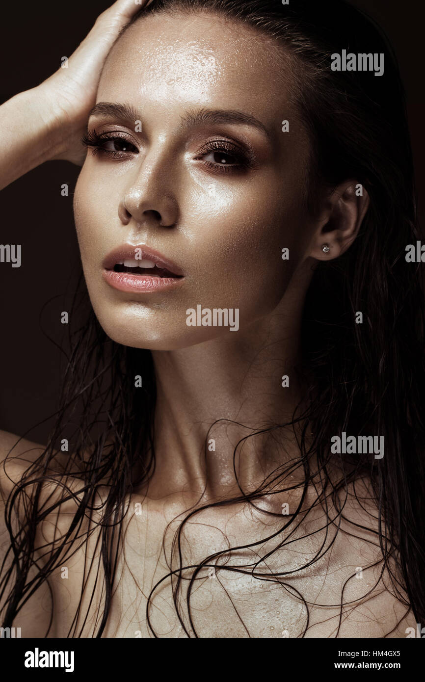 Beautiful girl with a bright make-up, wet hair and skin. Beauty face ...