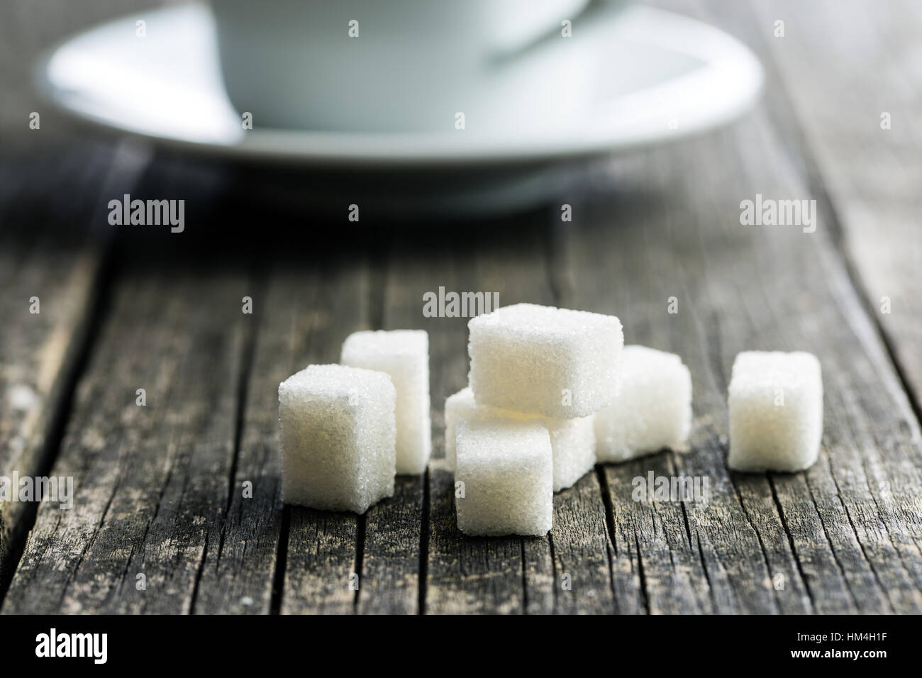 White sugar cubes on old wooden table Stock Photo - Alamy