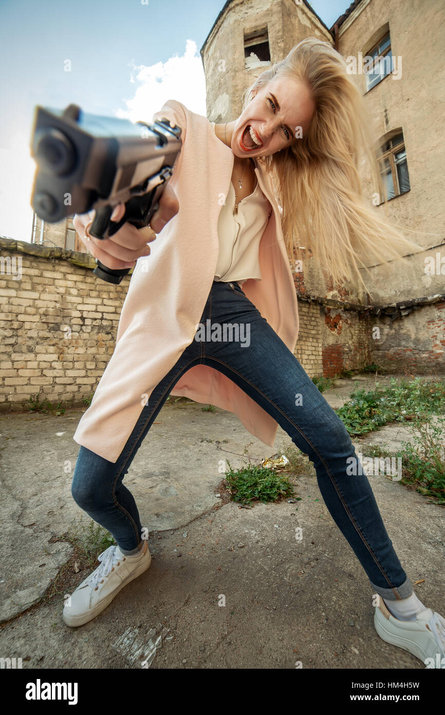 fun girl with gun screaming aiming at camera Stock Photo - Alamy