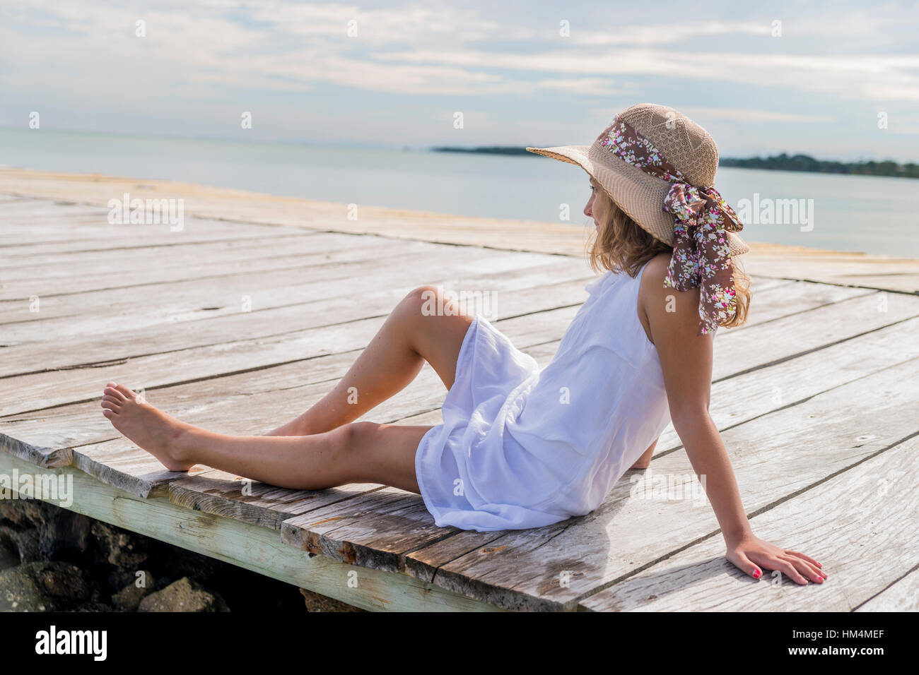 Girl contemplating the horizon from the jetty Stock Photo - Alamy
