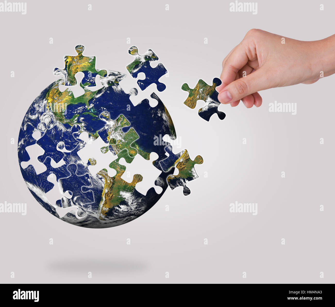 Business concept with a hand building puzzle globe Stock Photo - Alamy