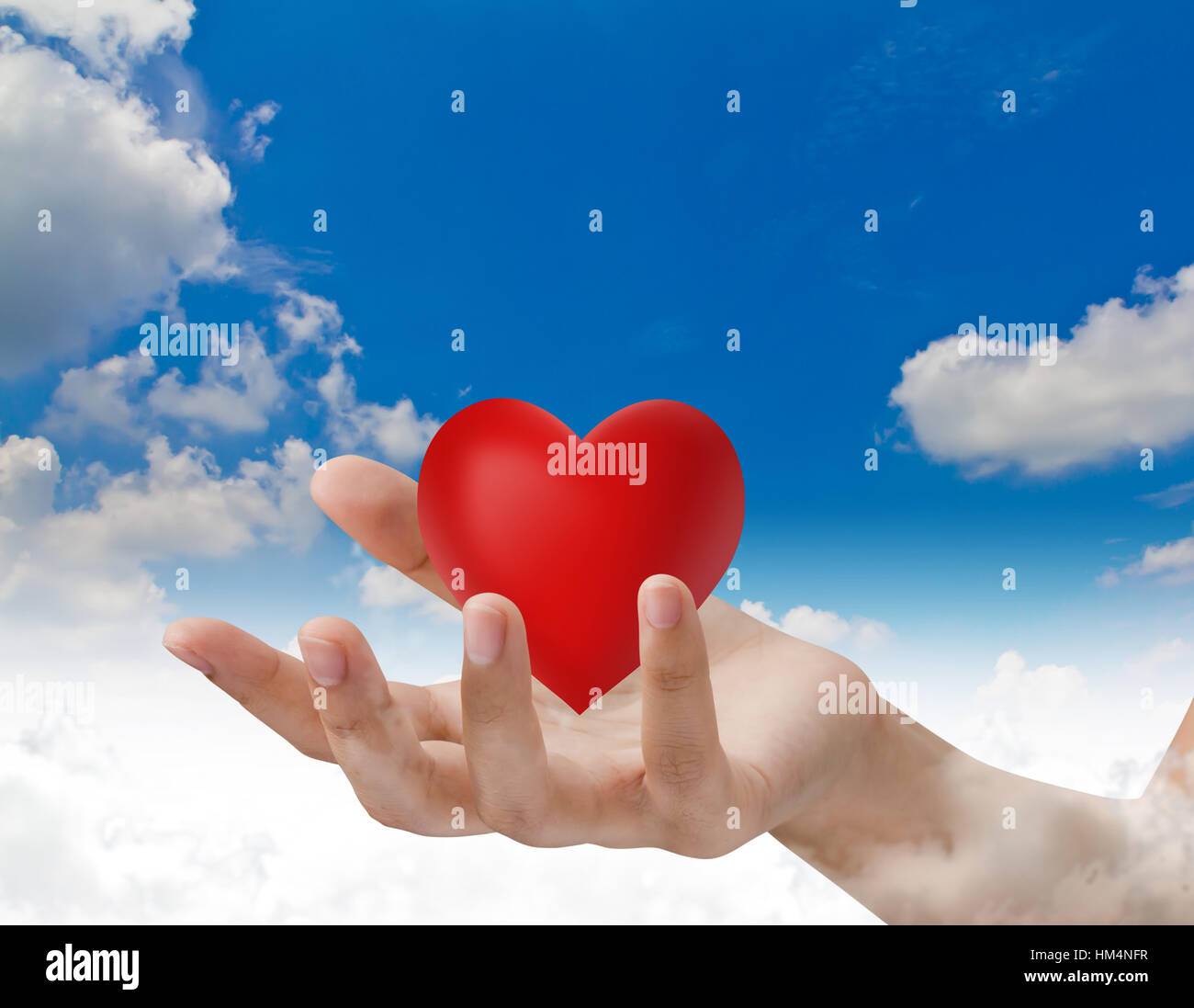 Red heart in woman hand over blue sky Stock Photo - Alamy