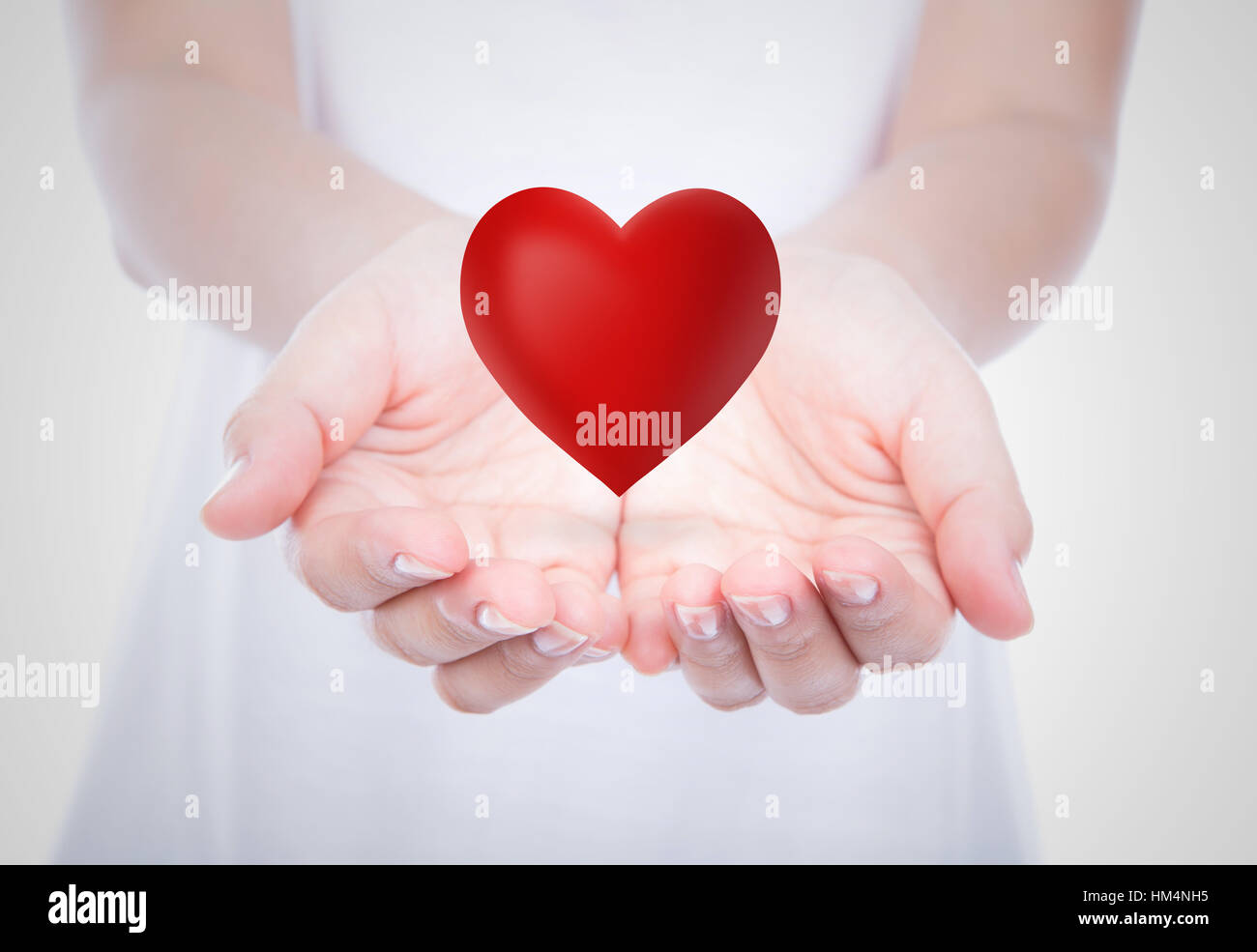 Heart on woman hands over body Stock Photo - Alamy