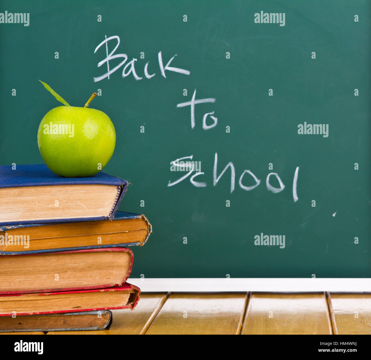 Back to school written on chalkboard with green apple and books Stock ...