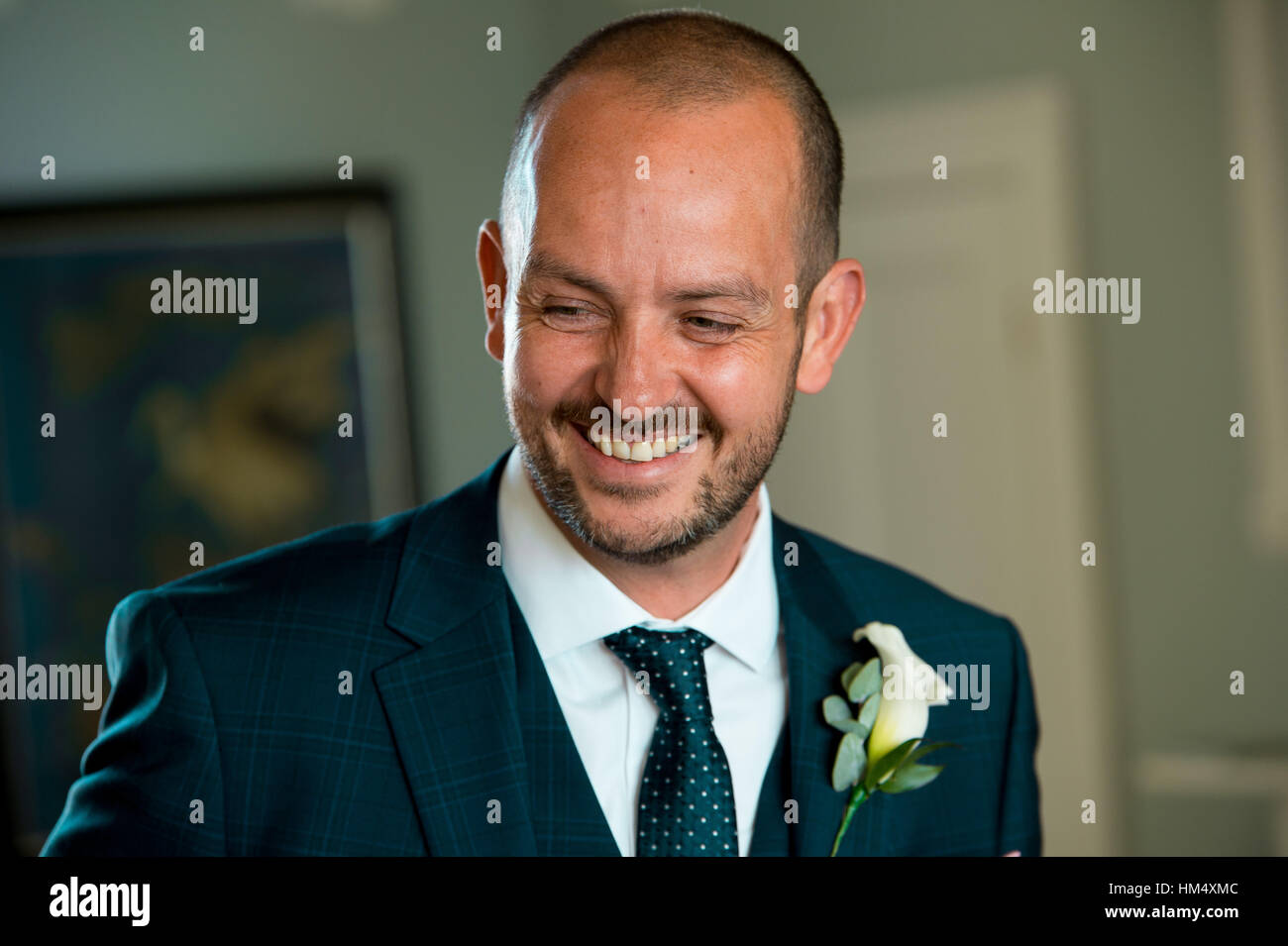 A happy groom smiles with joy in the moments leading up to meeting his ...