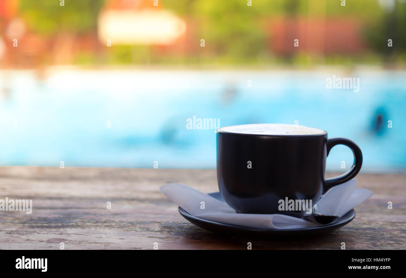 Cup of coffee on wooden deck near Swimming pool Stock Photo - Alamy