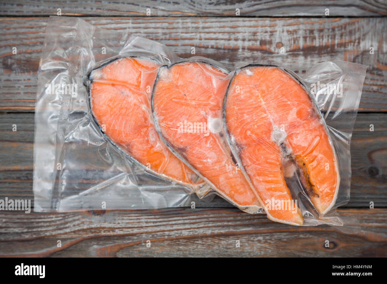 Frozen salmon fillets in a vacuum package wood table Stock Photo - Alamy