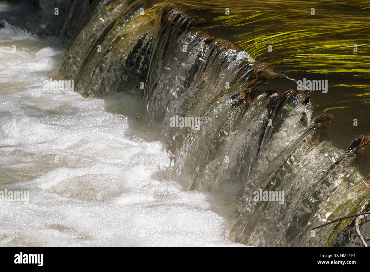 Water tumbling down weir Stock Photo - Alamy