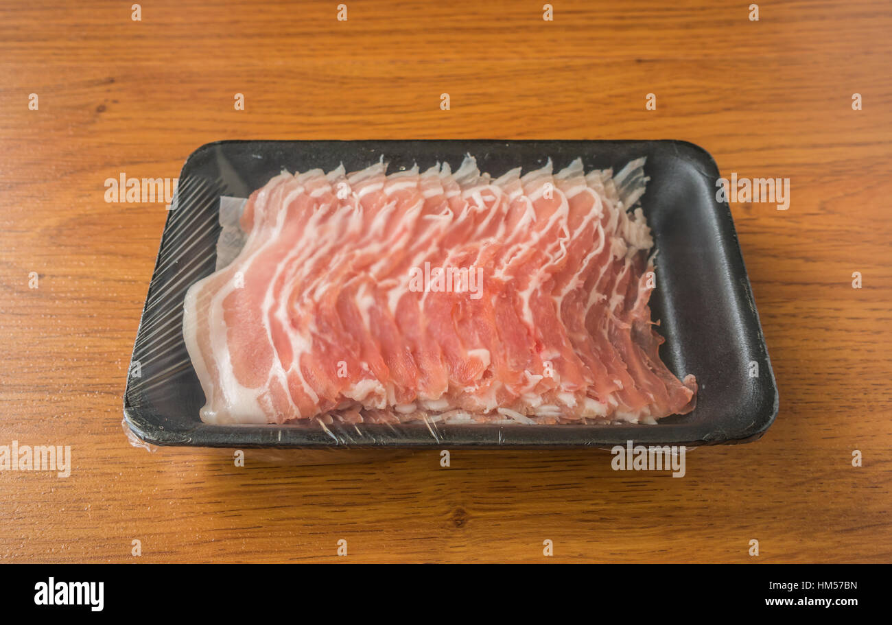 Slide raw pork on wood table Stock Photo - Alamy