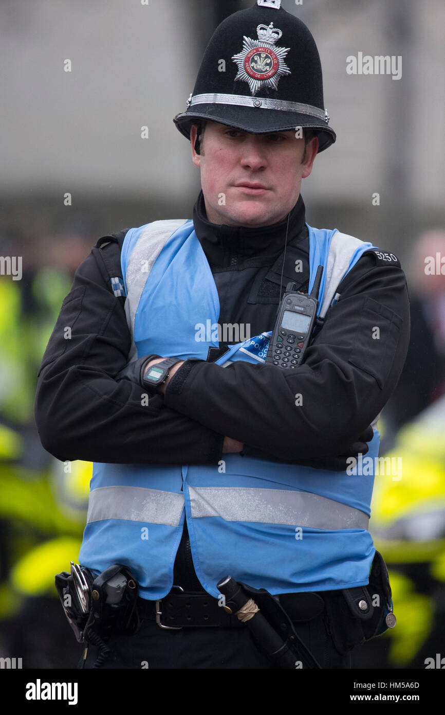 A police officer stands with his arms crossed in Cardiff, South Wales ...