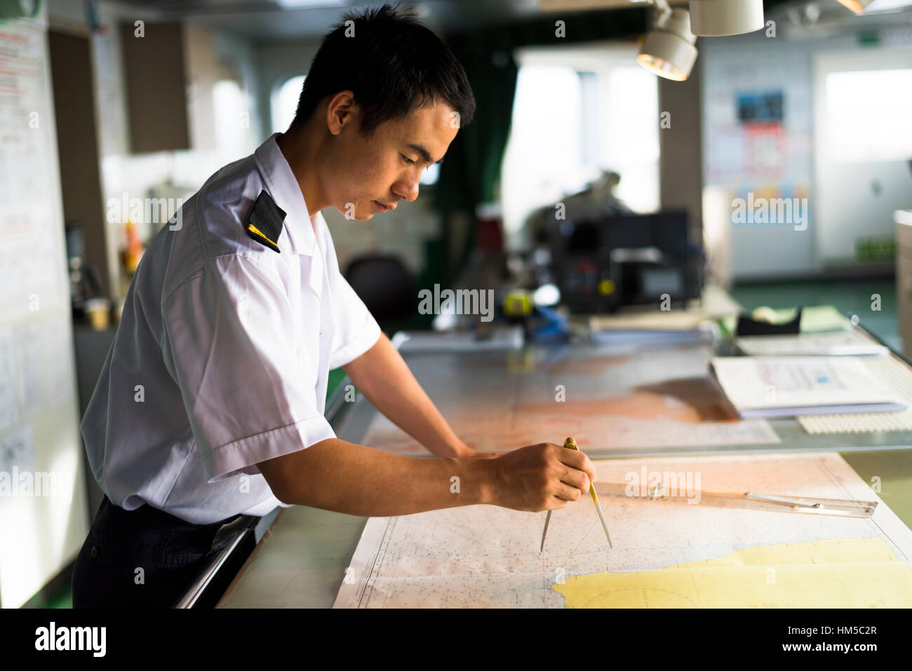 Young Chinese navigator on bridge, navigating his ship at sea Stock ...