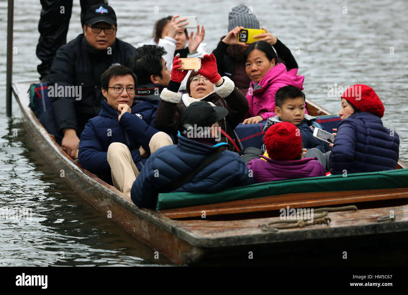 Tourists rap up against the cold as they take a punt along the river ...