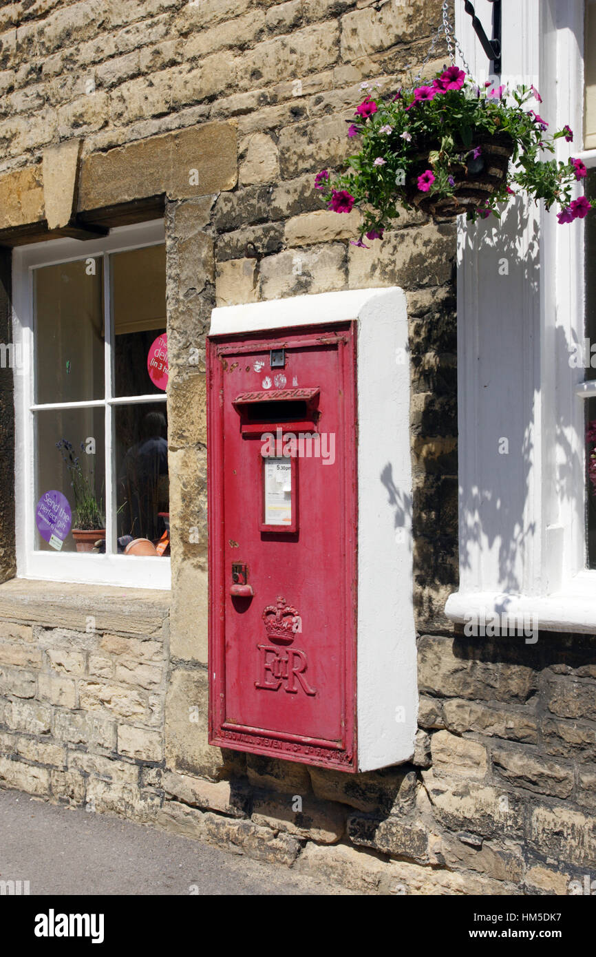 An old red post box set in cotsold stone wall in Stow on the Wold, a ...