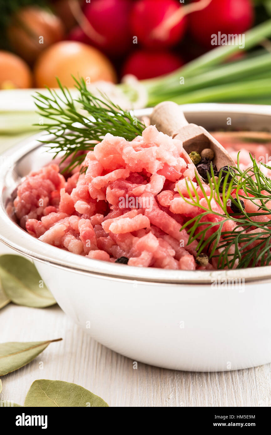 Raw ground meat in white bowl. Minced pork on a background of fresh ...