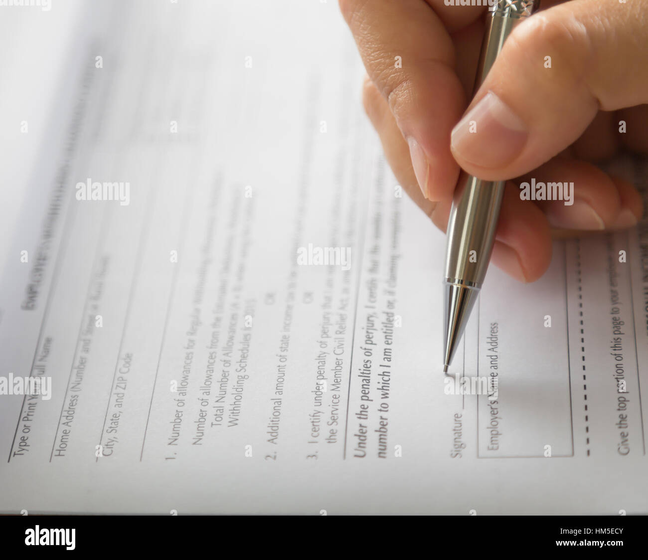Hand with pen over application form Stock Photo - Alamy